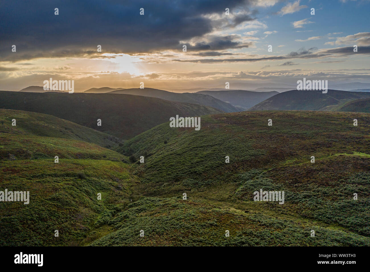 Aerial view over rolling upland landscape with dramatic sunrise clouds ...