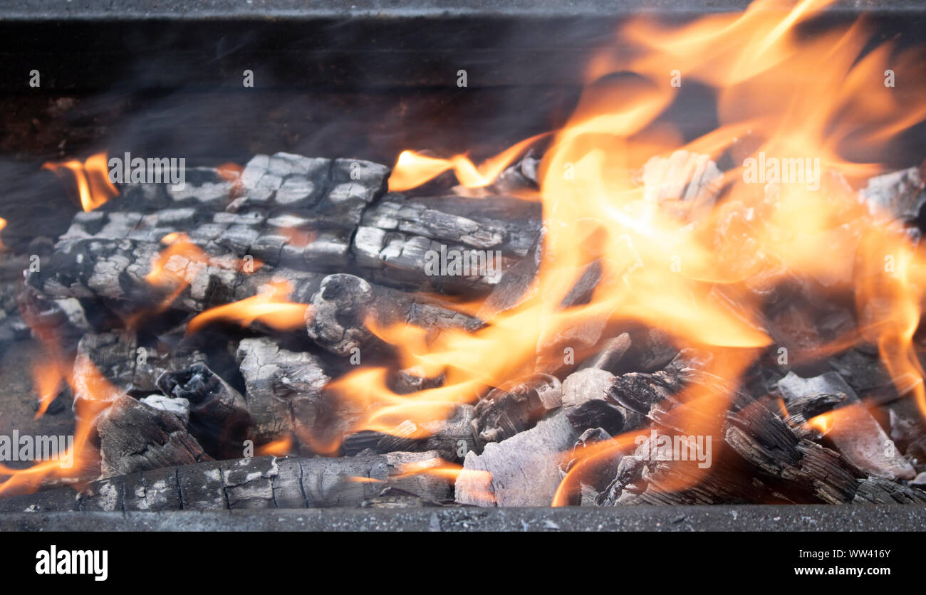 potato baked in charcoal, flame of fire. Close up Stock Photo - Alamy