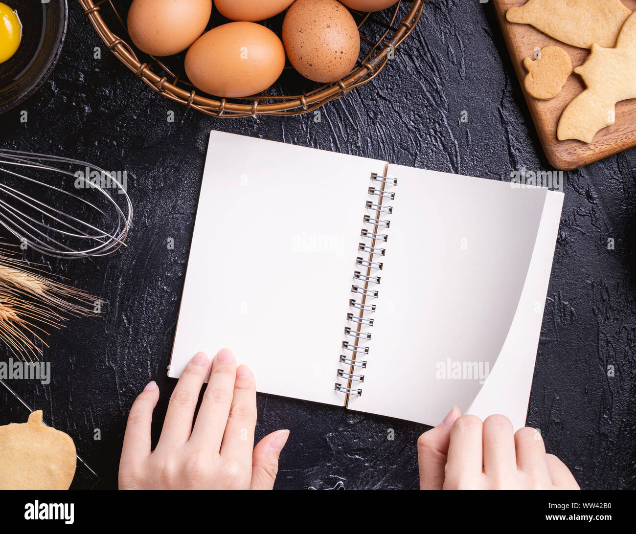 Woman is reading cookbook recipe of making Halloween cookies with ...