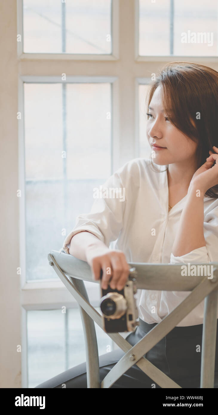Portrait of beautiful professional photographer holding camera while ...