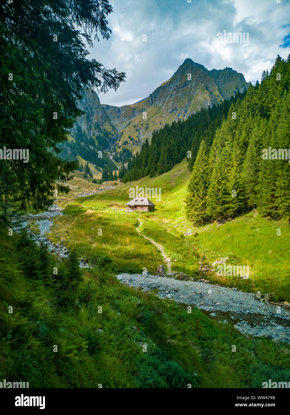 Wooden house in the middle of a mountainous landscape with forest and ...