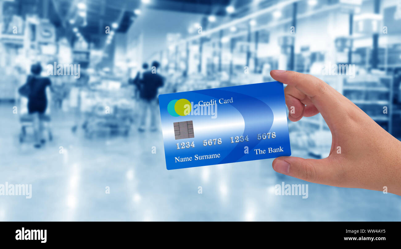 Hand holding credit card on super market blur background, online ...