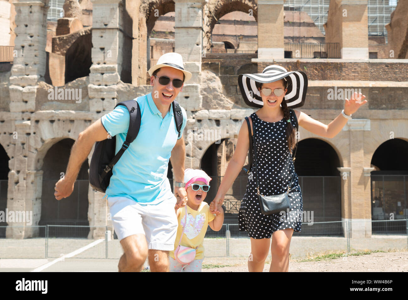 Young Tourist Family Running In Front Of Colosseum In Rome, Italy Stock ...