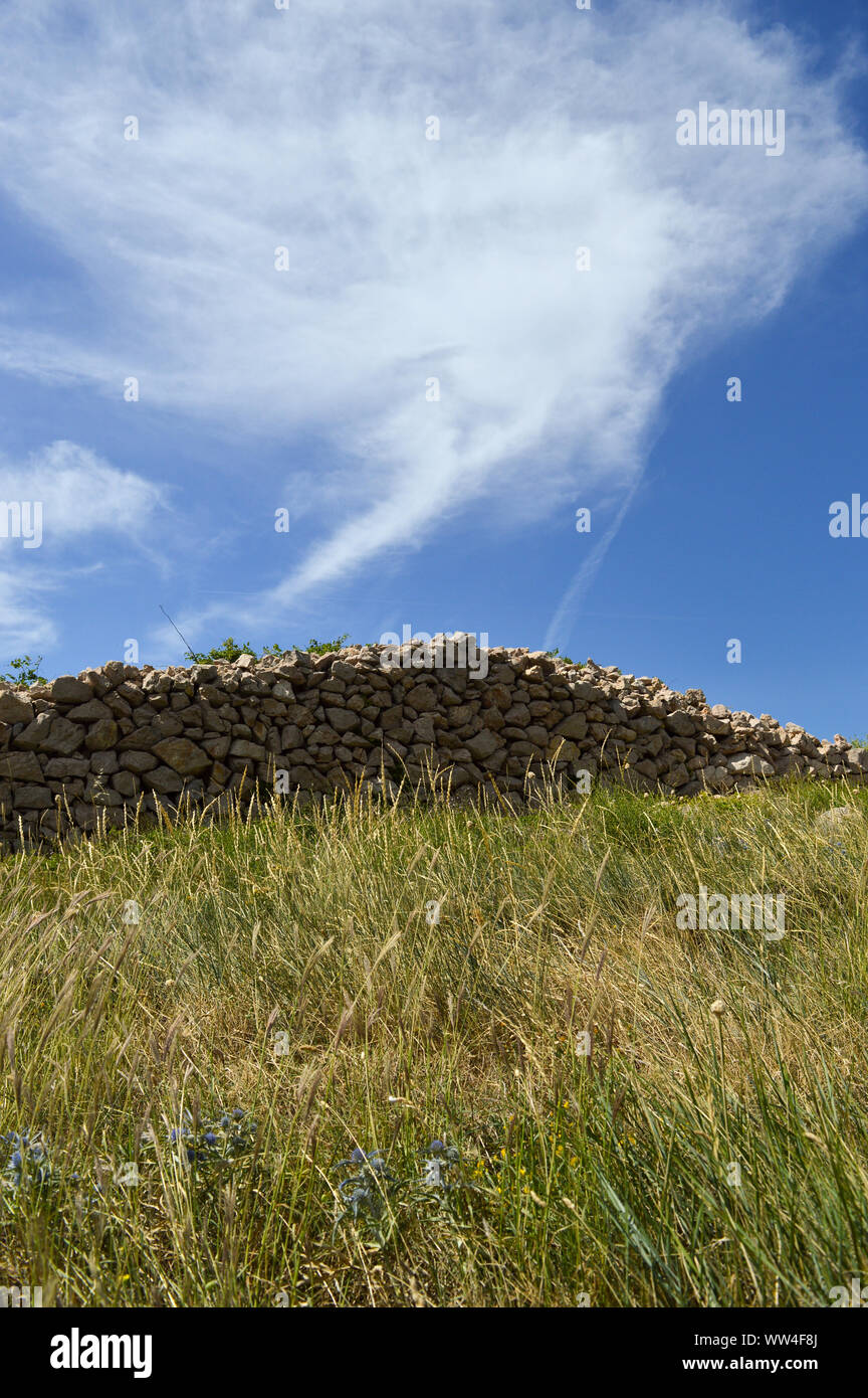 Handmade stone wall on top of hill, blue sky background Stock Photo - Alamy