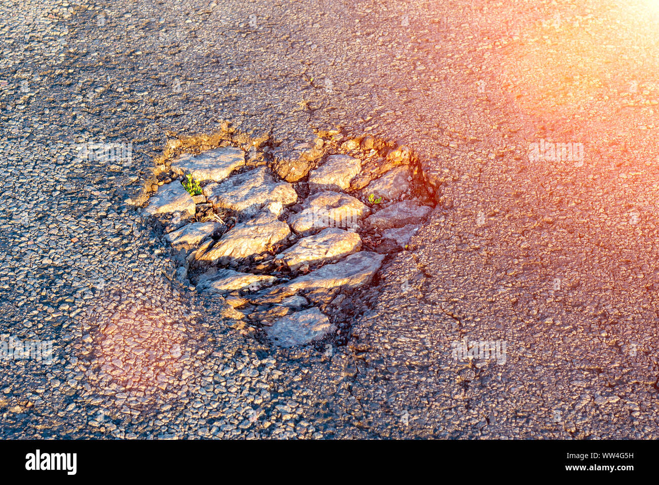 potholes on the asphalt the shape of a heart in the rays of the sun ...