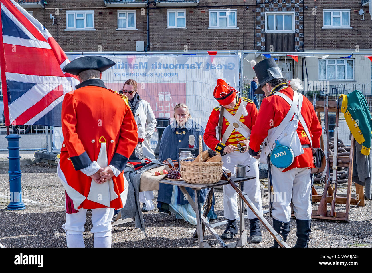 A group of men and women in period costume and wearing soldier and ...