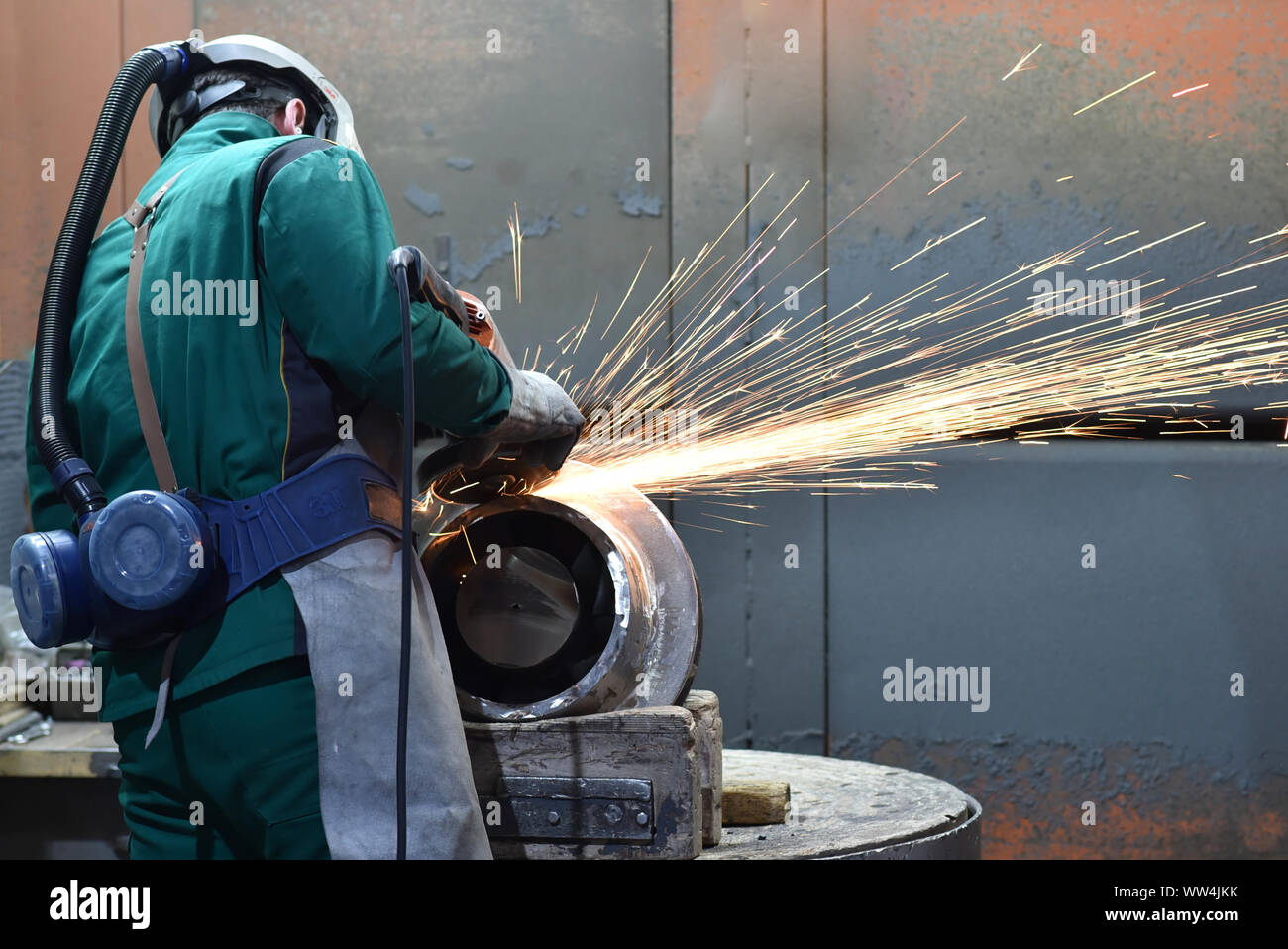 worker machined workpiece casting with a grinding machine - work safety ...