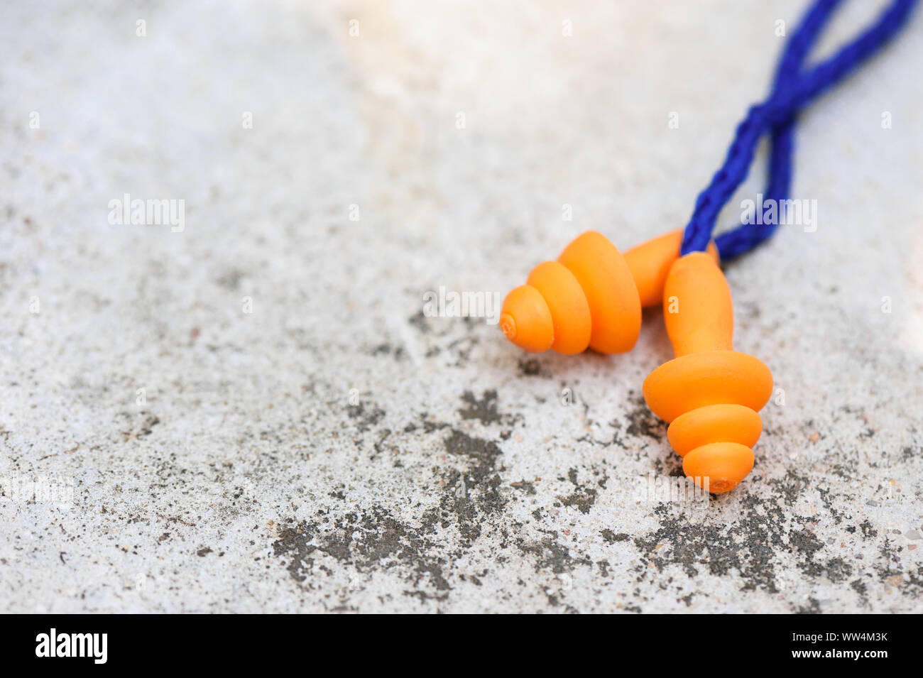 Orange reusable ear plugs in construction site, personal safety ...