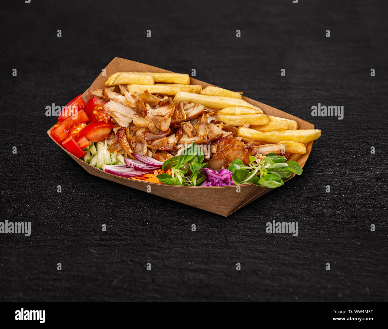 Greek gyros dish with french fries and vegetables in paper plate Stock ...