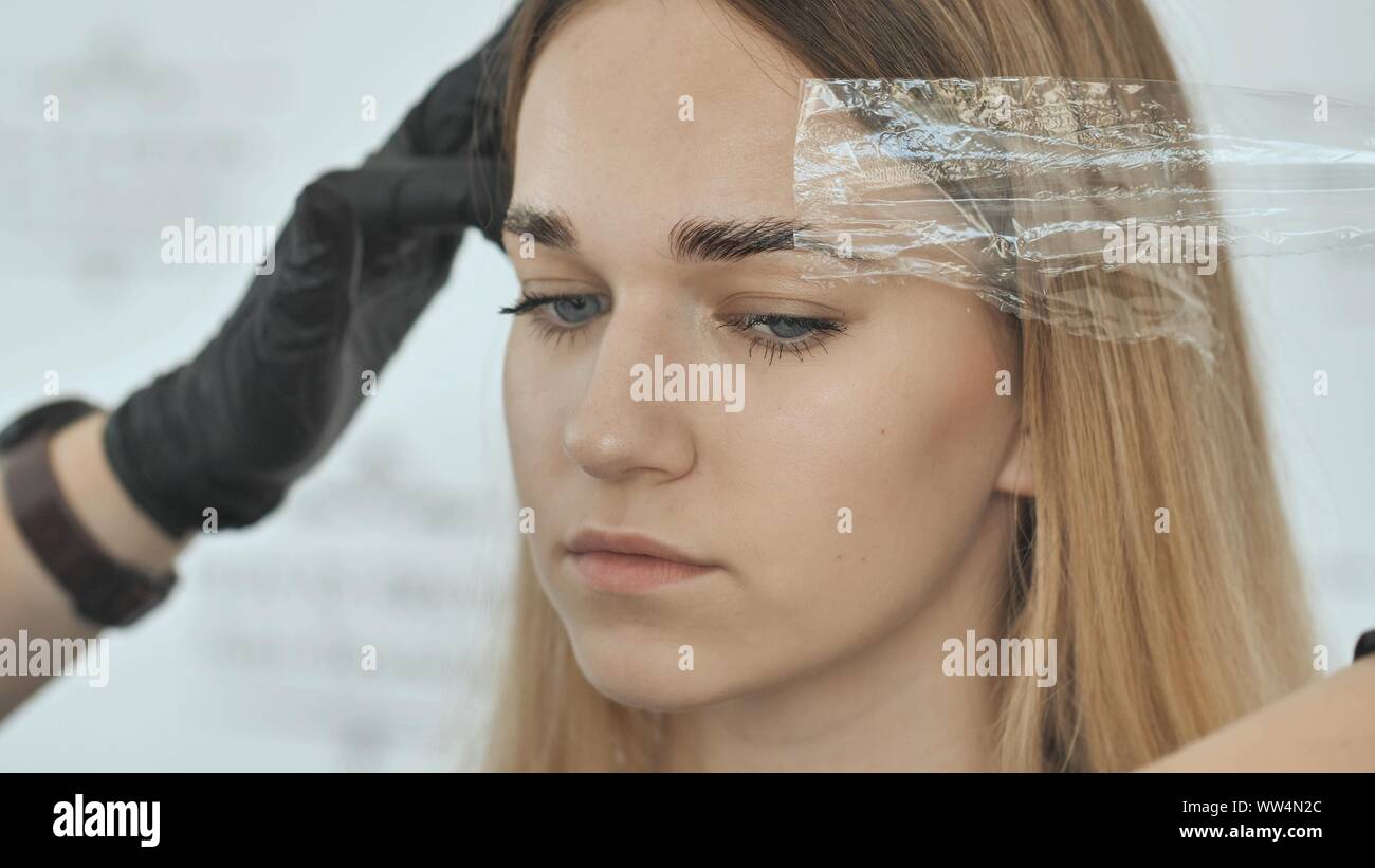 Removing the fixing film. Create permanent eyebrow makeup Stock Photo ...