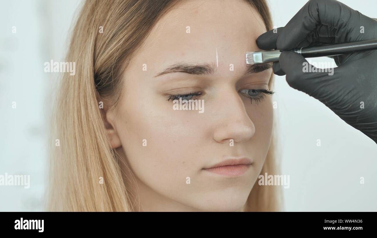 Create permanent eyebrow makeup. Marking the shape of the eyebrows ...