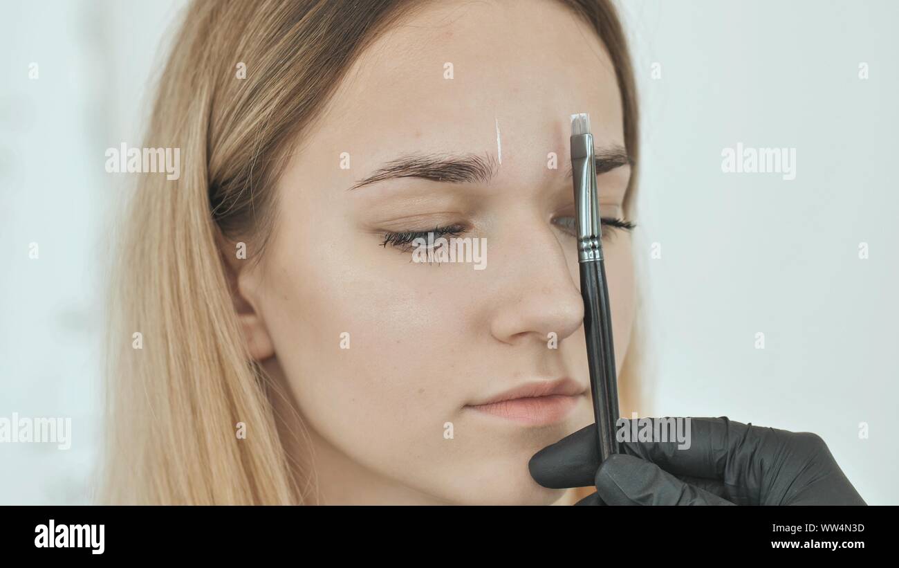 Create permanent eyebrow makeup. Marking the shape of the eyebrows ...