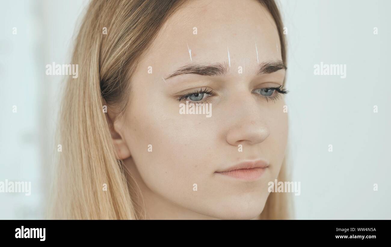 Create permanent eyebrow makeup. Marking the shape of the eyebrows ...