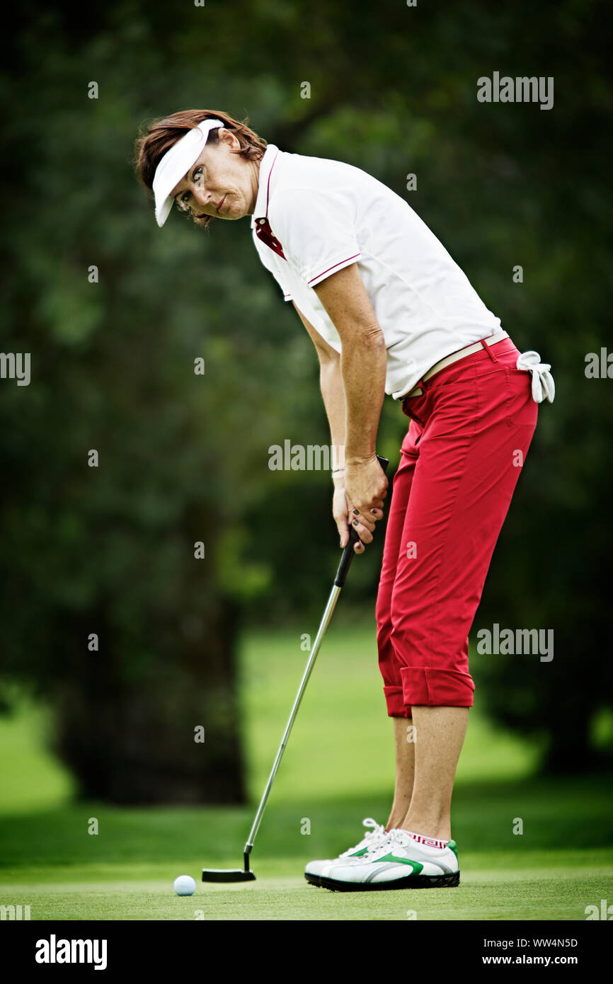 Female golfer putting Stock Photo - Alamy