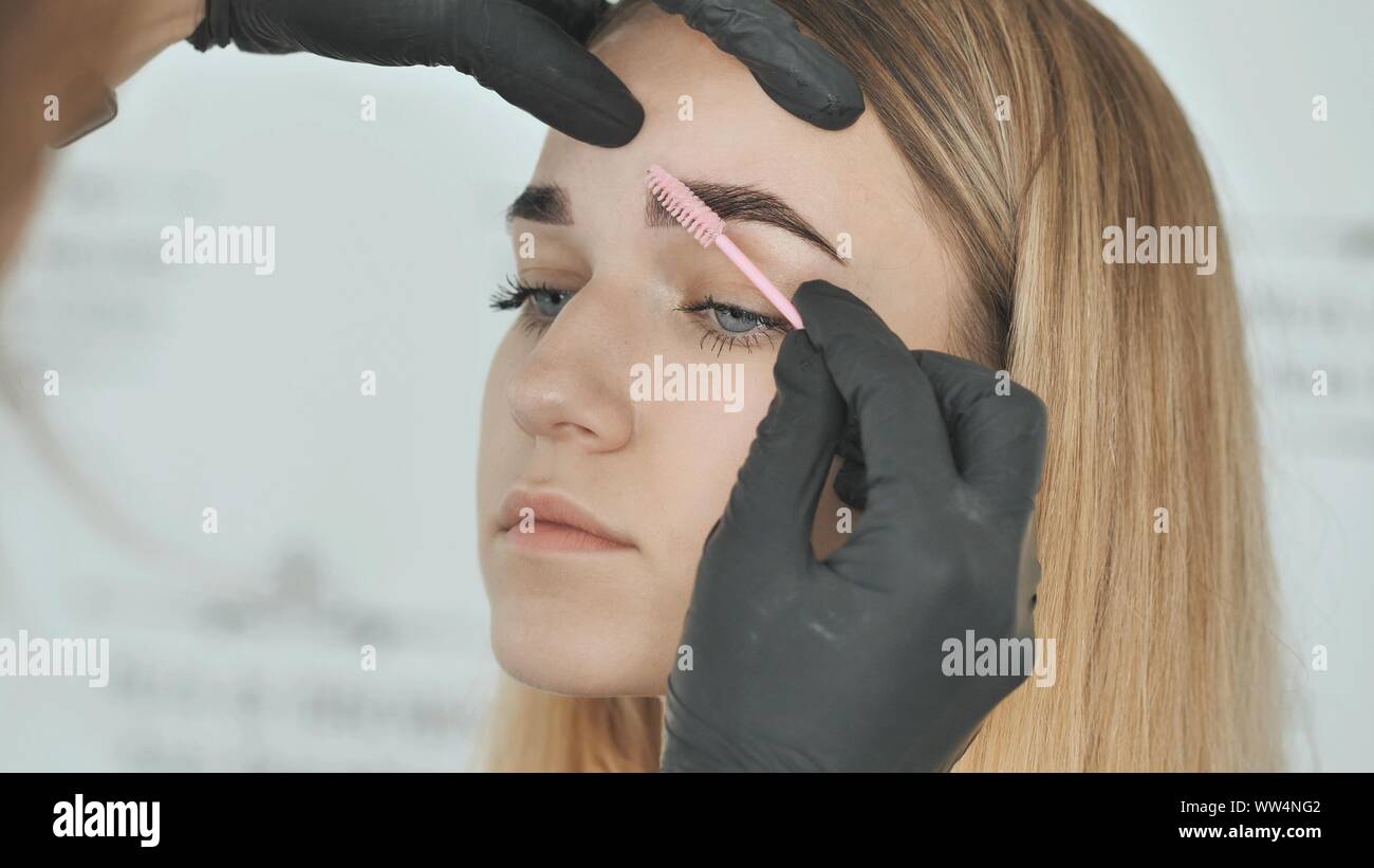 Create permanent eyebrow makeup. Combing eyebrows after dyeing Stock ...