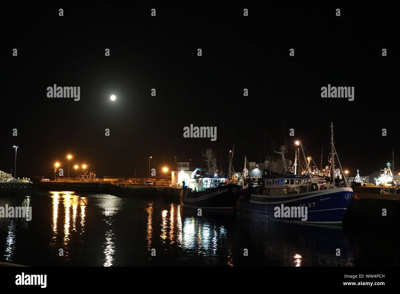 Fishing boats in harbour at night Stock Photo - Alamy