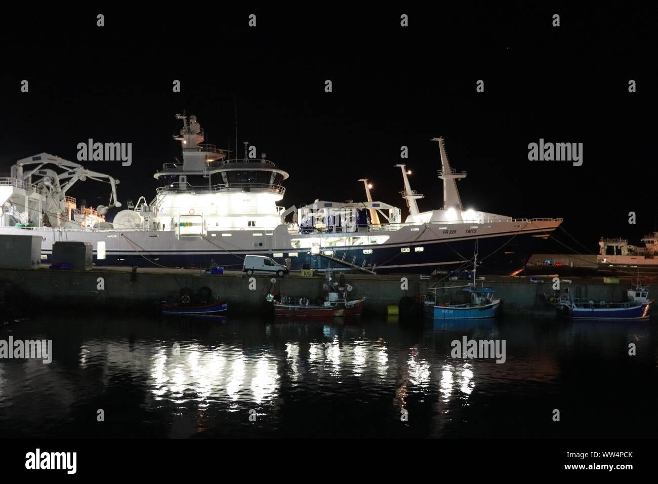 Fishing boats in harbour at night Stock Photo - Alamy