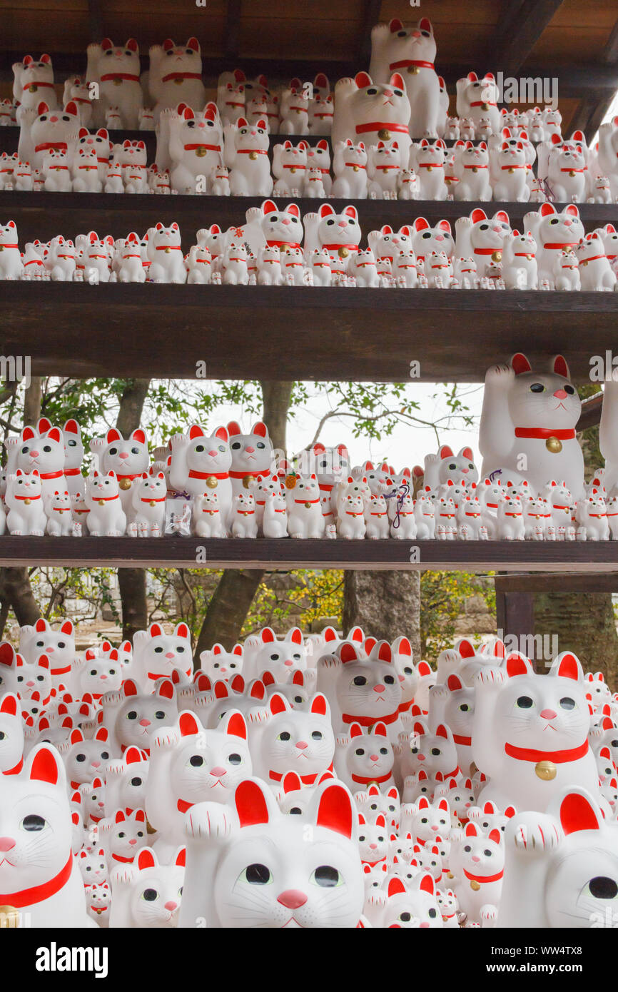 A numbers of Lucky Cat figurines on display on the shelf in outdoor ...
