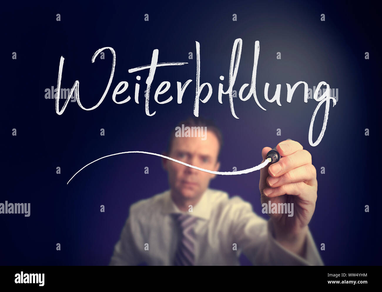 A businessman writing a Further Education "Weiterbildung" concept in ...