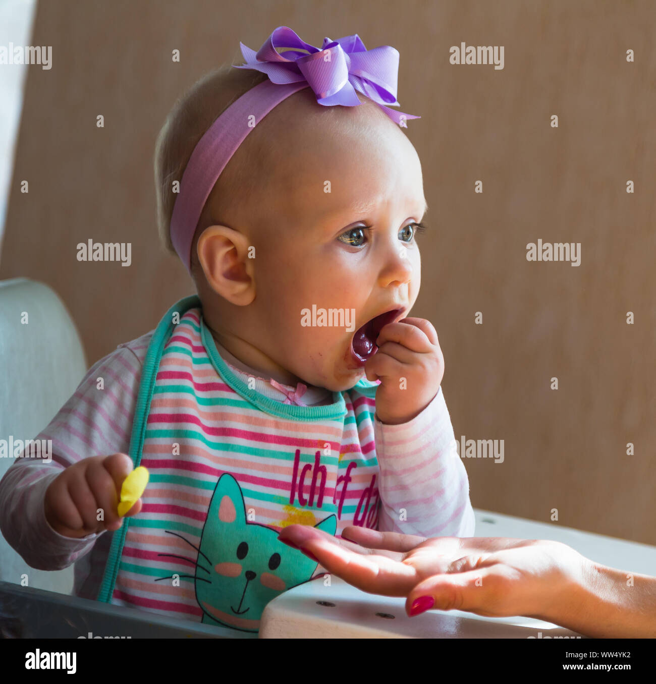Baby learns to eat herself Stock Photo - Alamy