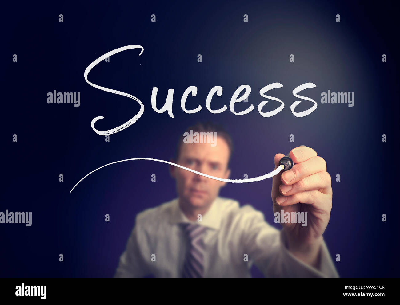 A businessman writing a Success concept with a white pen on a clear ...