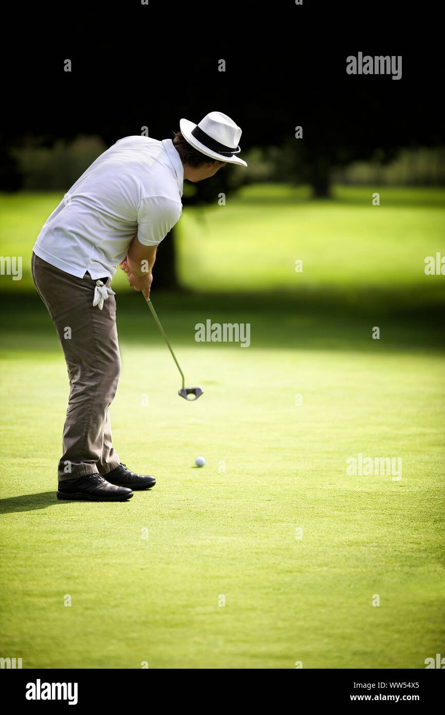 Male golfer putting Stock Photo - Alamy