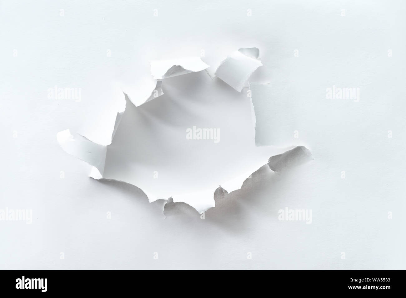 Teared paper hole in white paper over white background for your text or ...