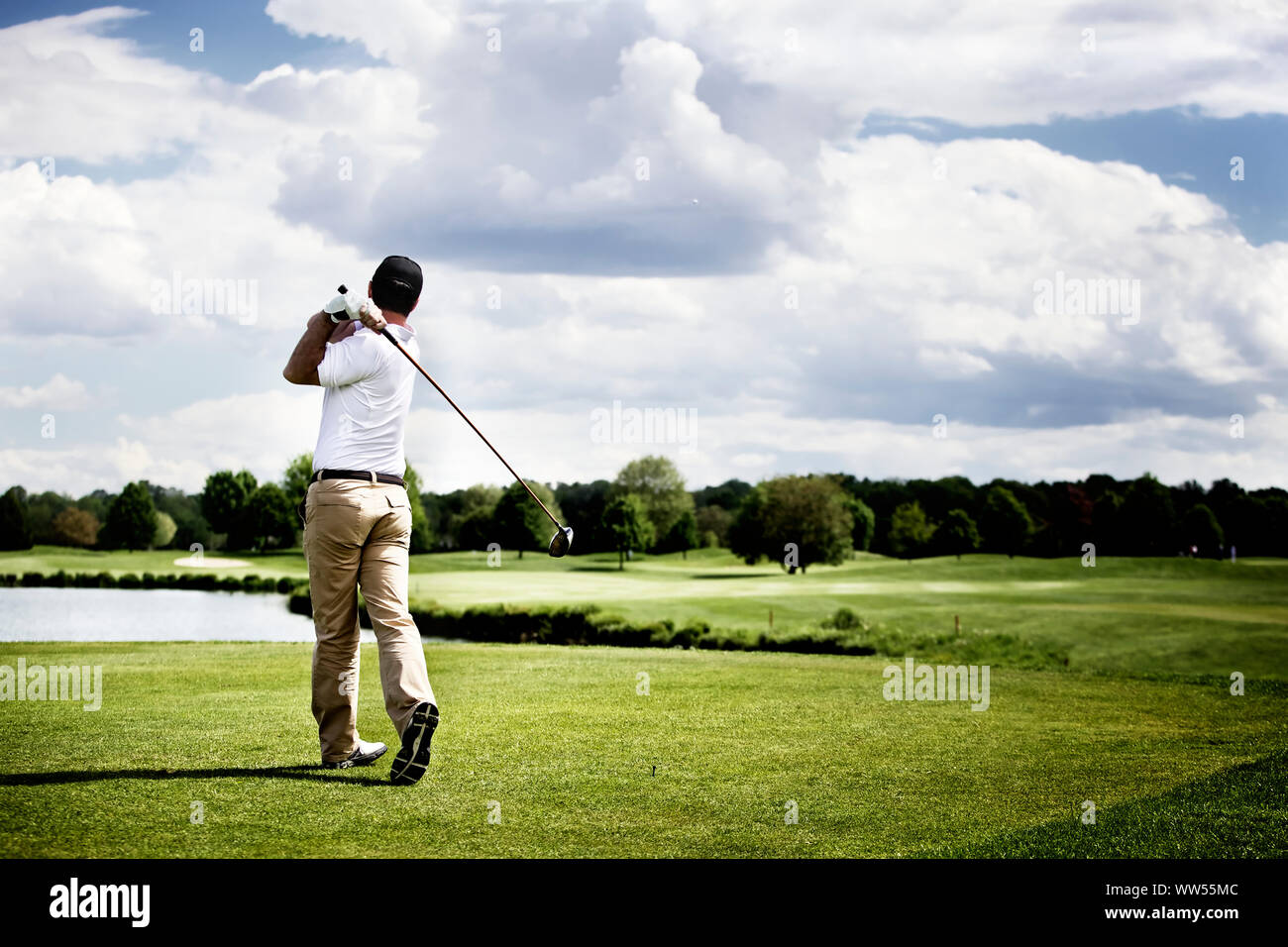 Golf player teeing off Stock Photo - Alamy