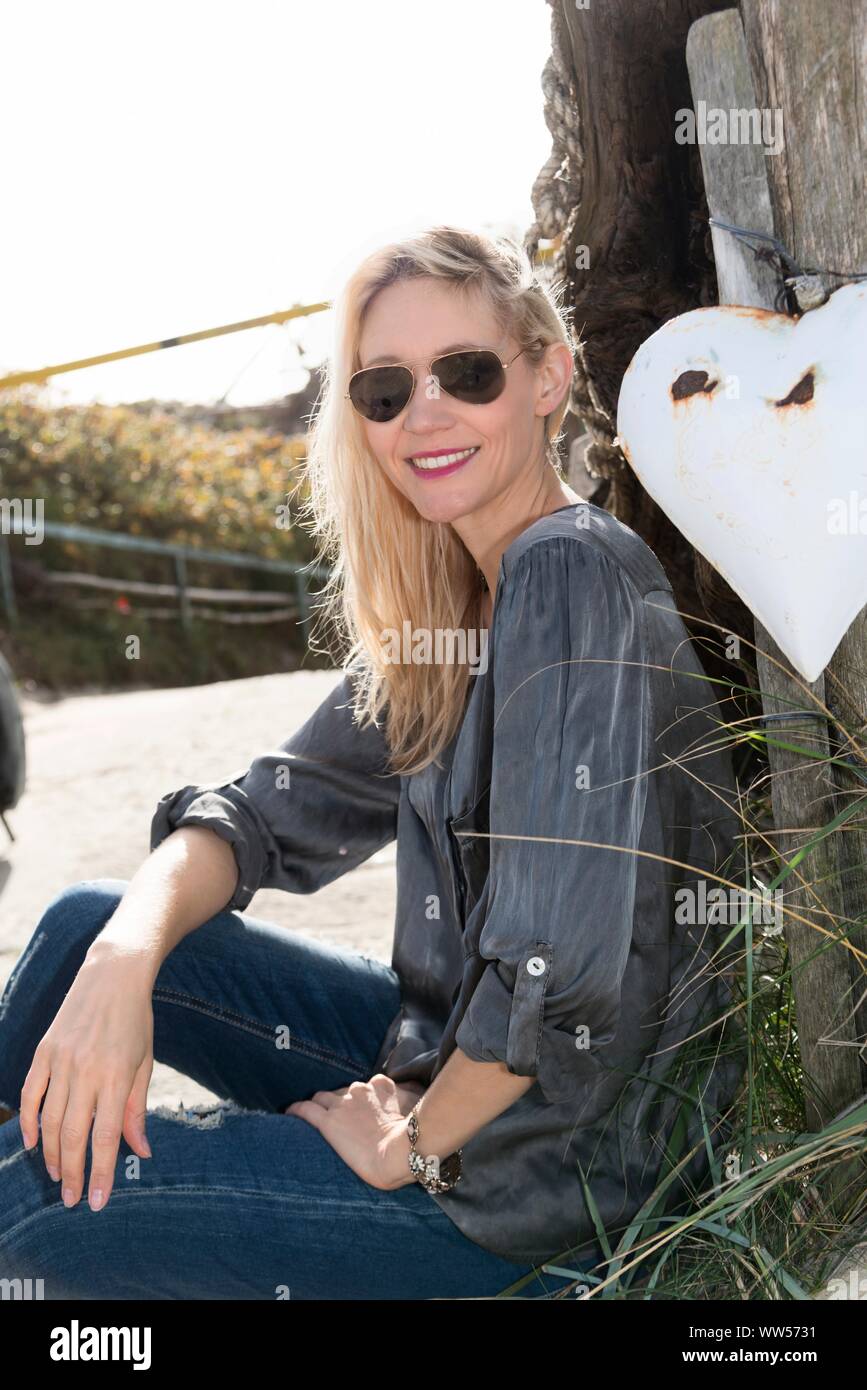 Woman sitting on fence hi-res stock photography and images - Alamy
