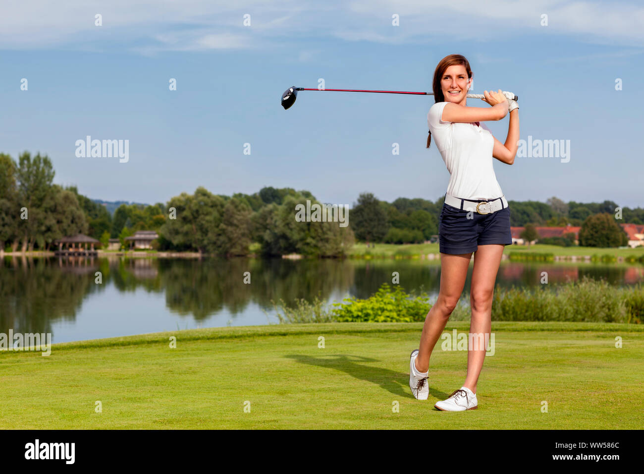 Golf player teeing off Stock Photo - Alamy