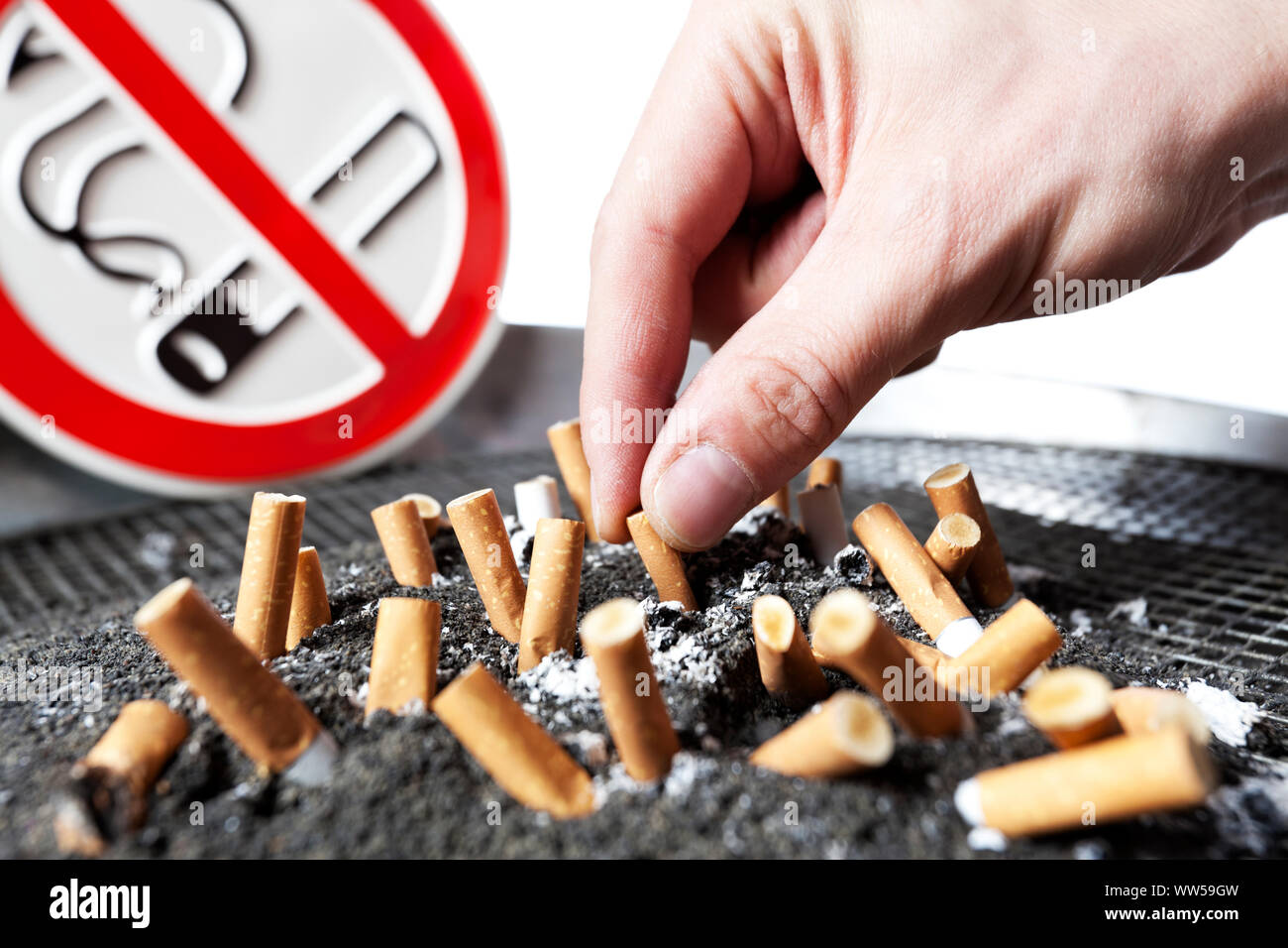 Cigarette stubs in ash with hand and no smoking sign Stock Photo - Alamy