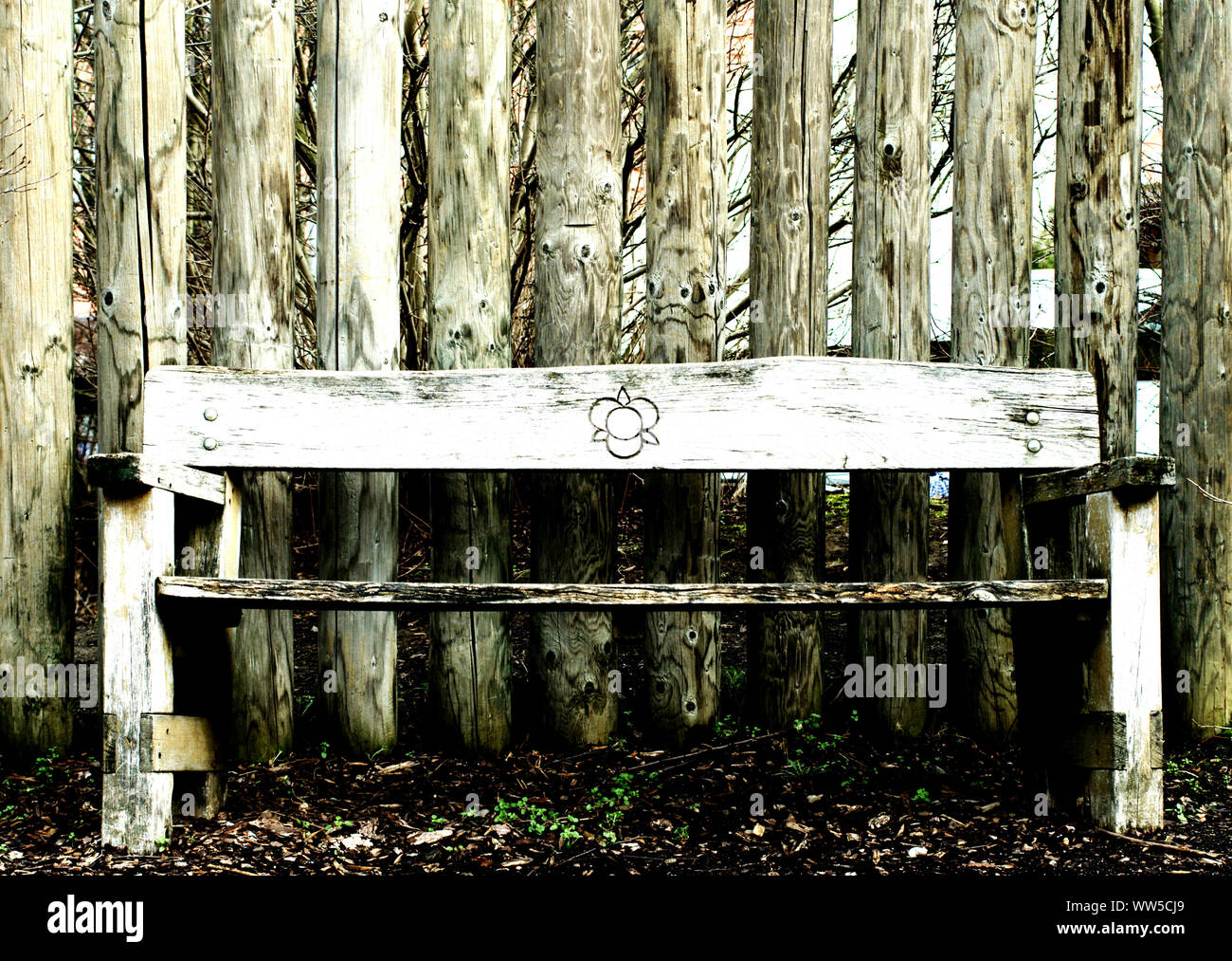 Front view on a park bench in front of a wall with round planks Stock ...