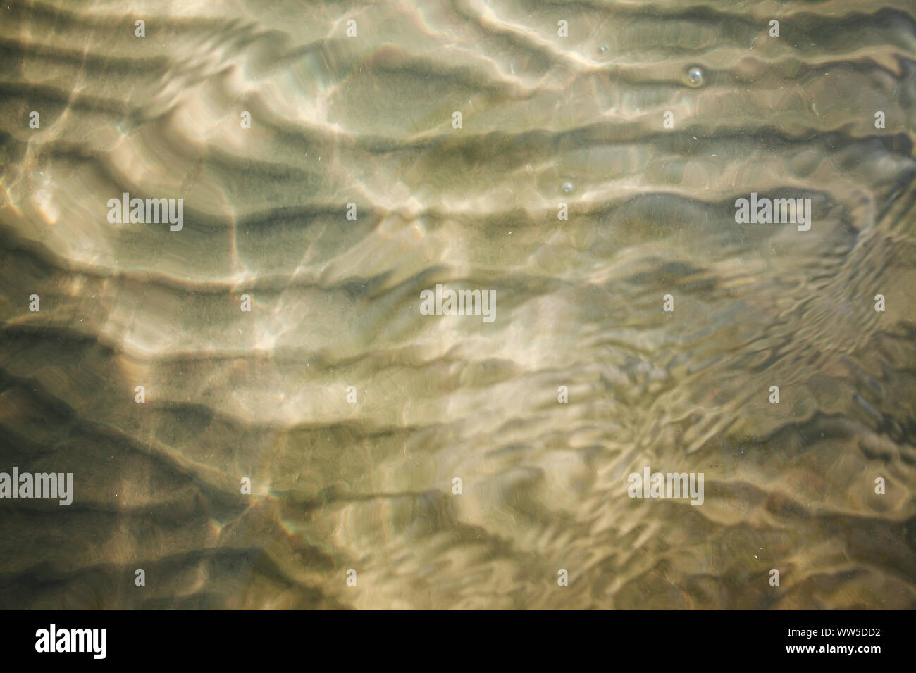 Abstract of underwater surface, sand and small waves viewed from above ...