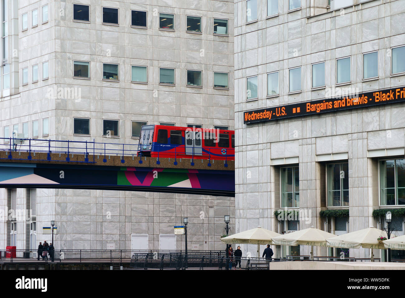 A red underground of the DLR line on a bridge passing high rises in the ...