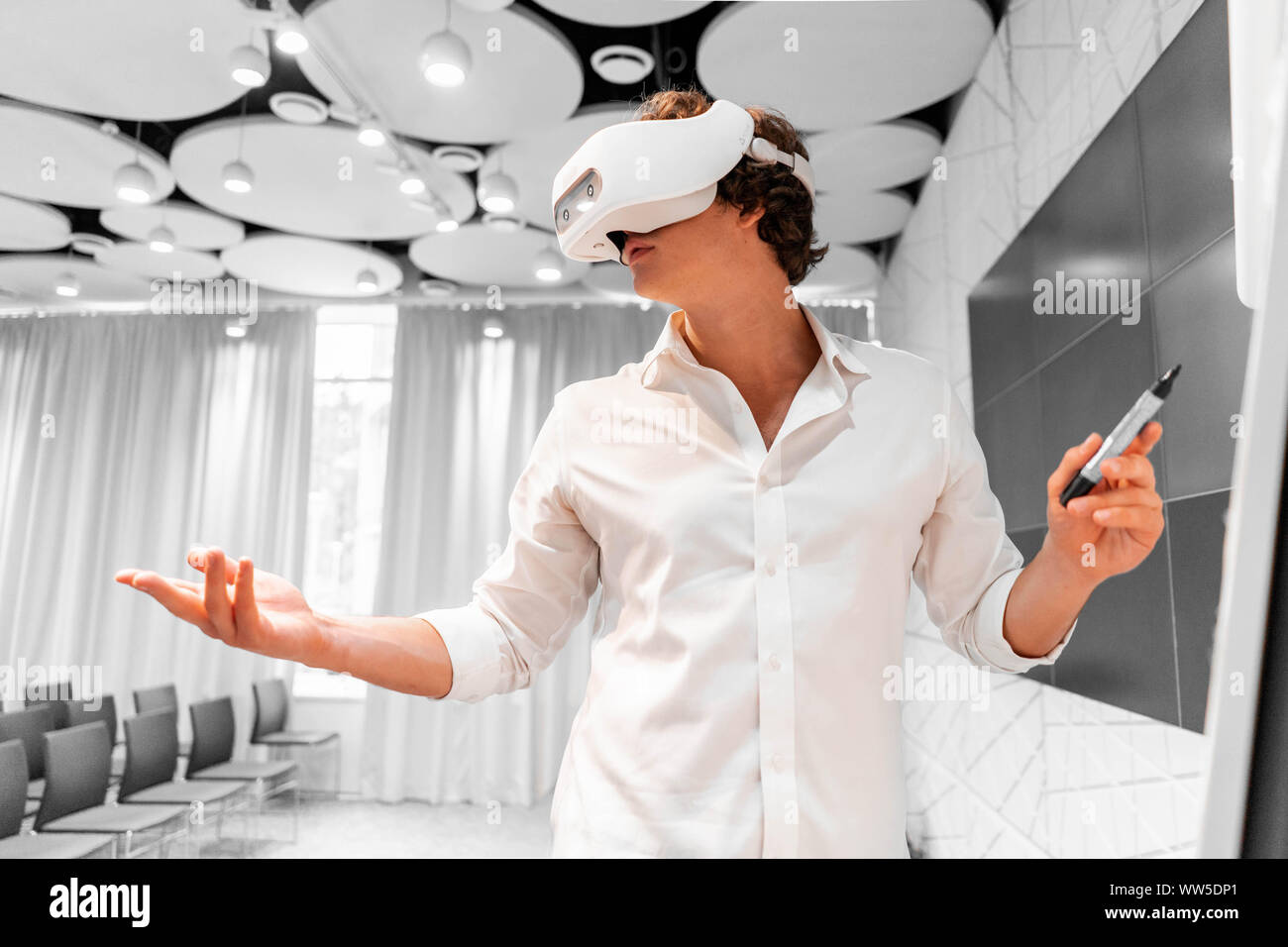 Man wearing virtual reality goggles in modern contemporary bright co ...