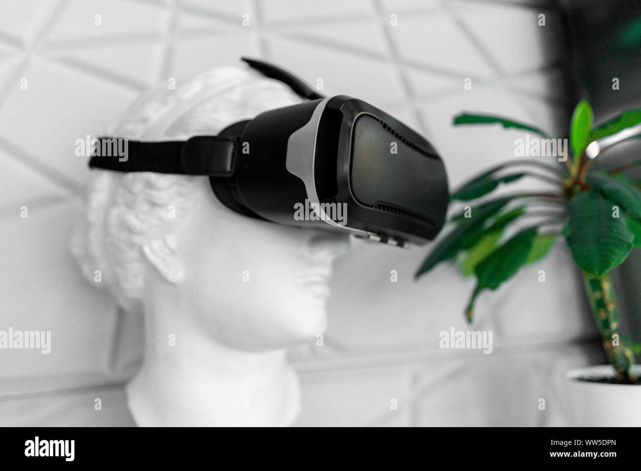 Close up of plaster bust wearing virtual reality goggles in modern ...