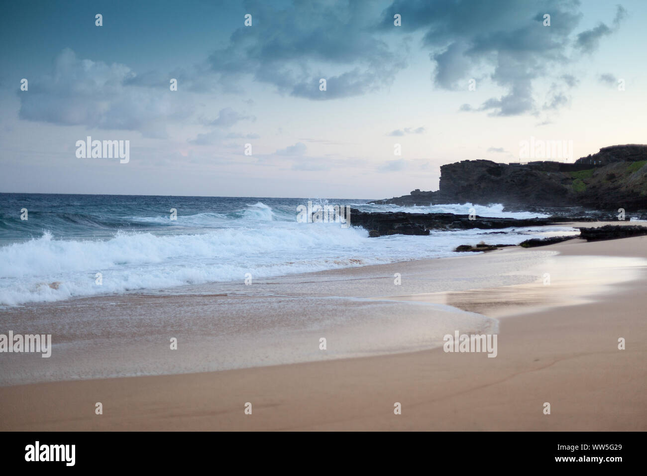 Sandy beach and rocky coast at sundown, Oahu, Hawaii, USA Stock Photo ...