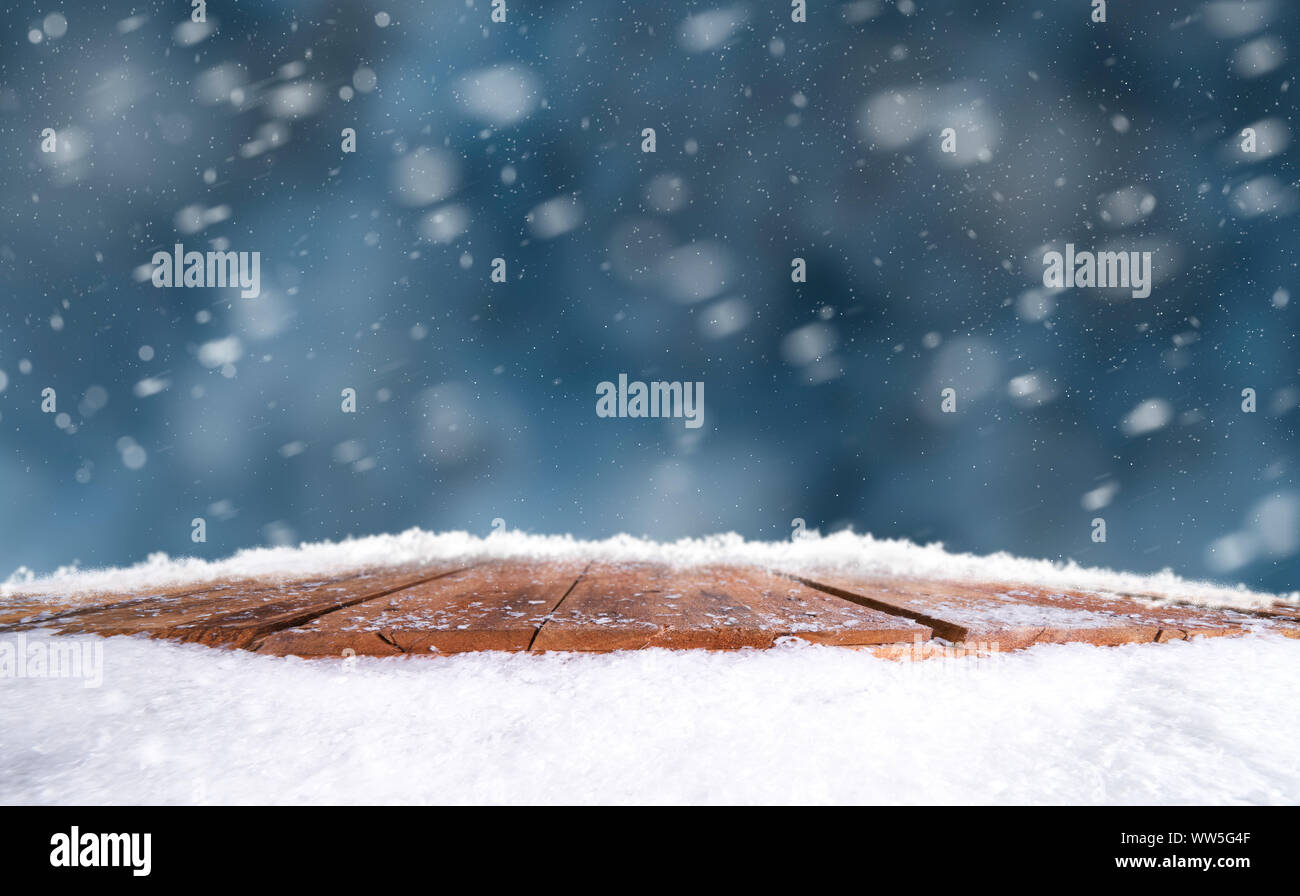 Wooden table, bench covered in snow with a Christmass, wintery and ...