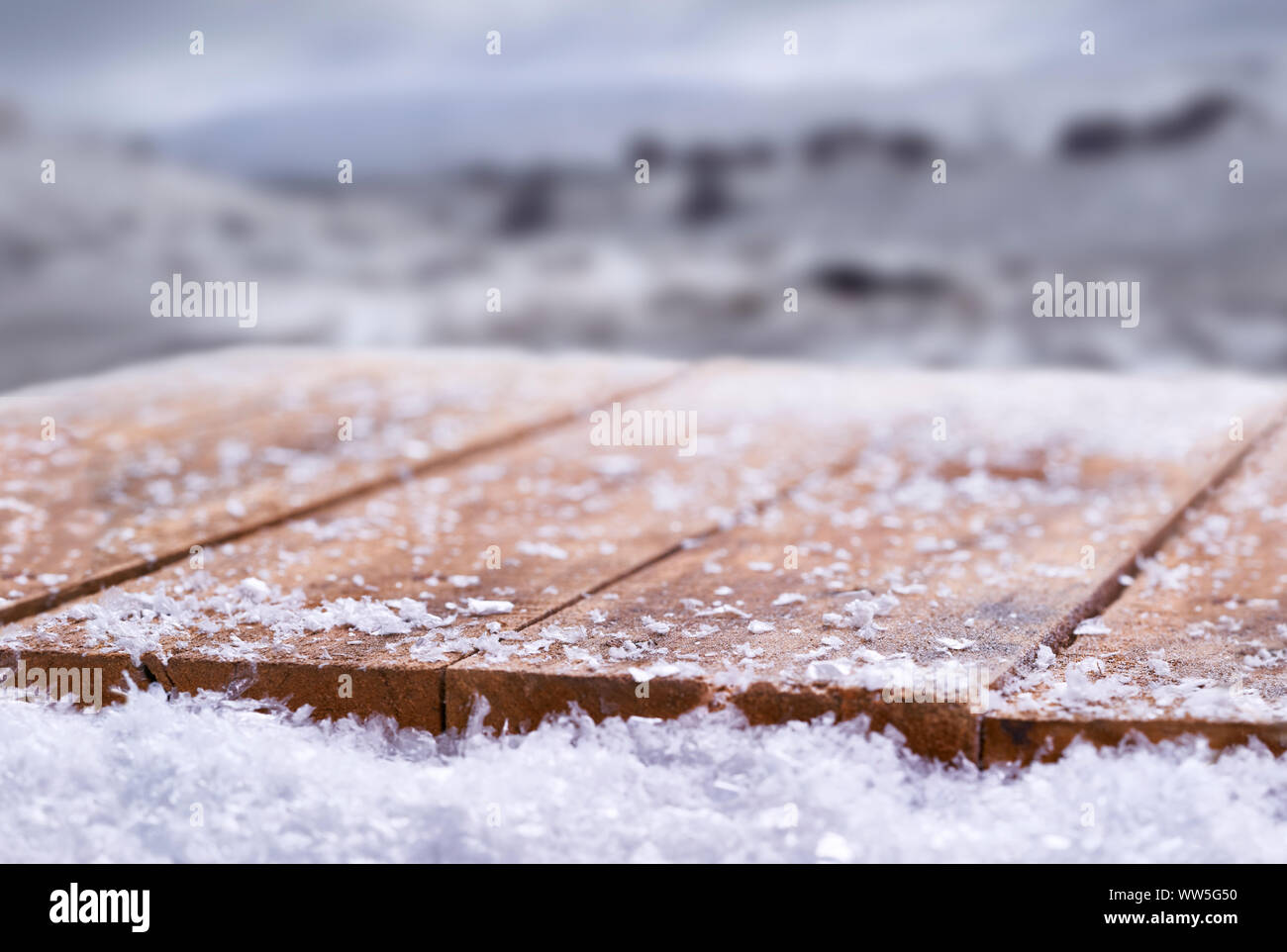 Wooden table top covered in snow with a Christmass, winter and snowy ...