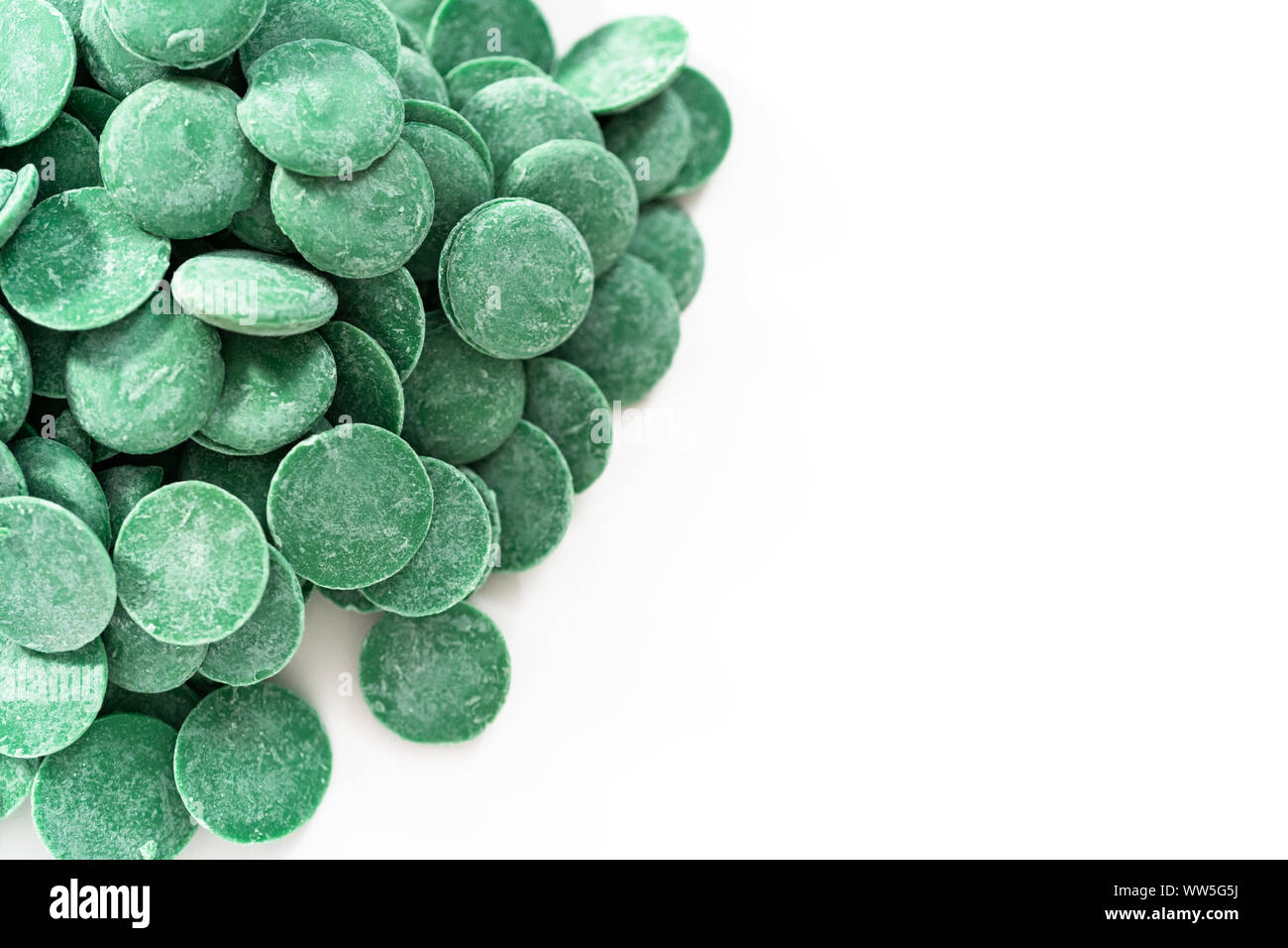 Green round chocolate chips for melting chocolate shapes on a white ...