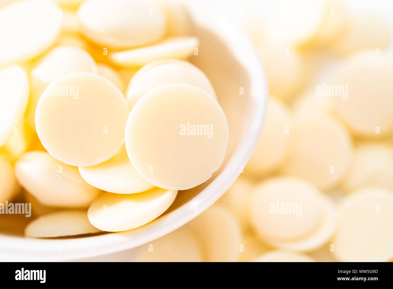 White round chocolate chips for melting chocolate shapes on a white ...