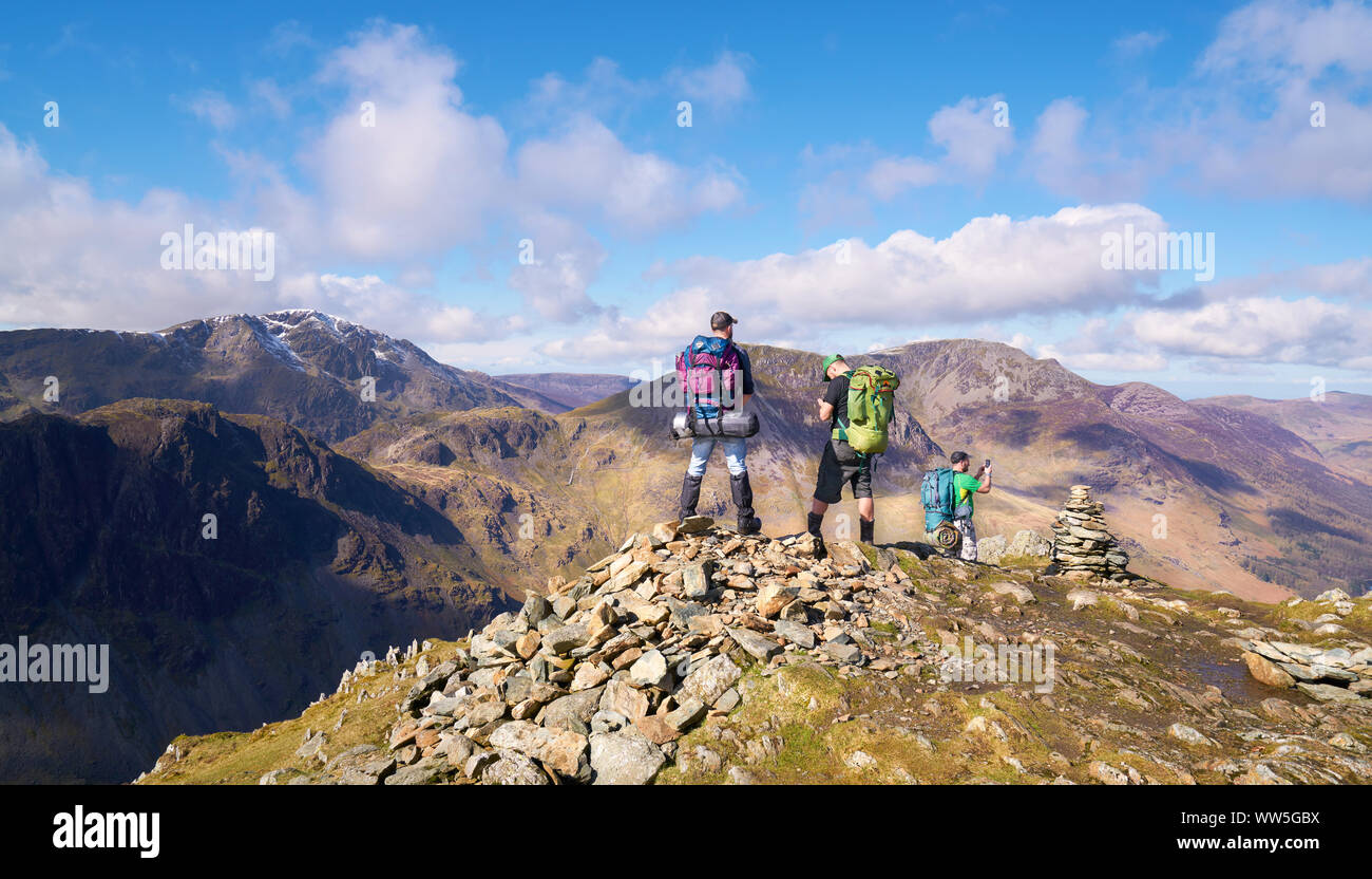 Three hikers looking out over the summits of High Crag, High Stile and ...