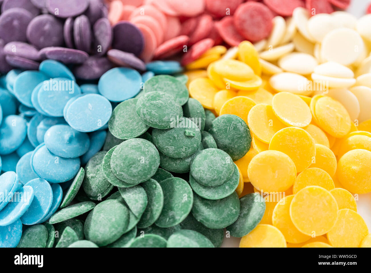 Rainbow colors of round chocolate chips for melting chocolate shapes on ...