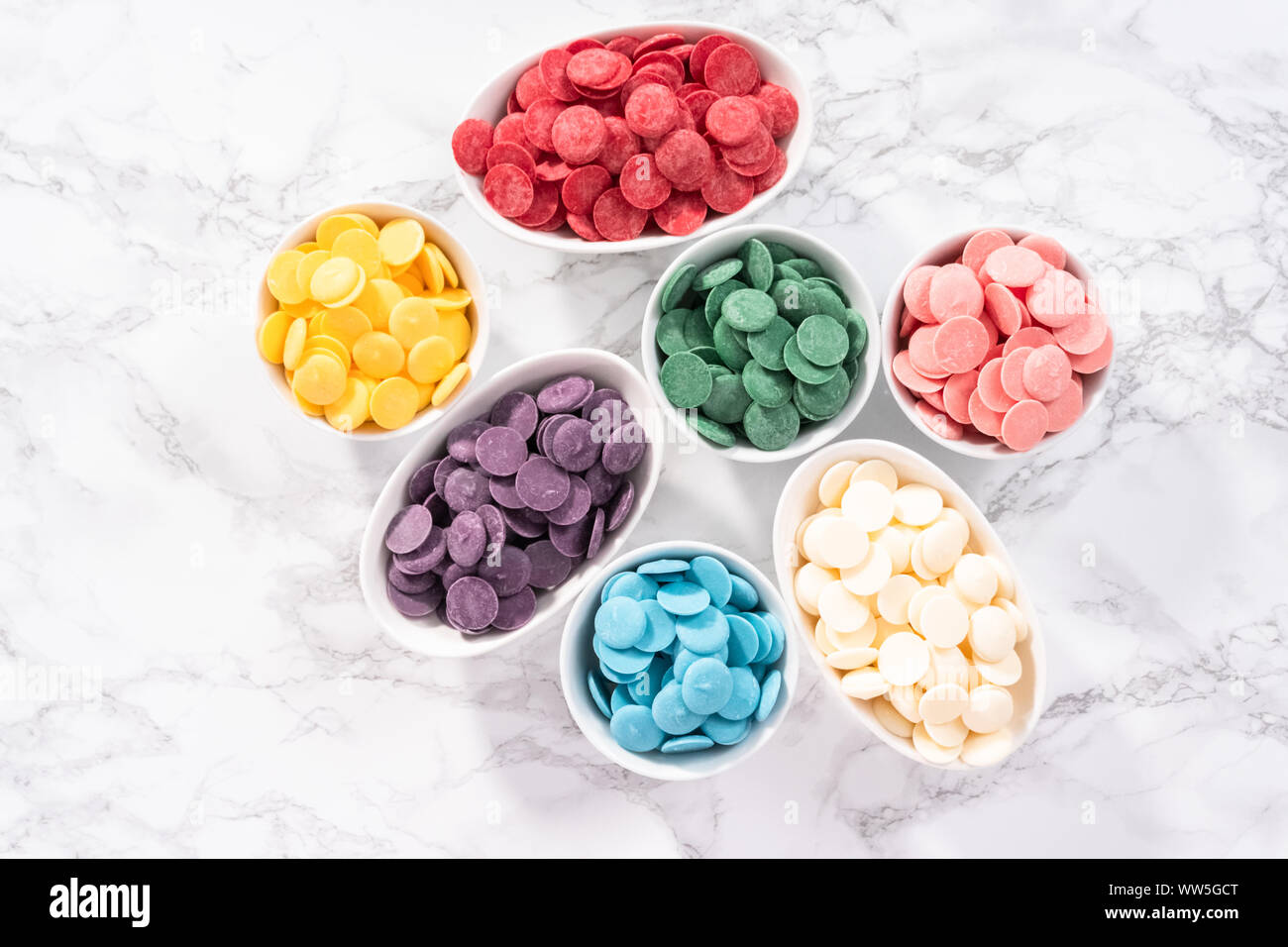 Flat lay. Pink round chocolate chips for melting chocolate shapes on a ...