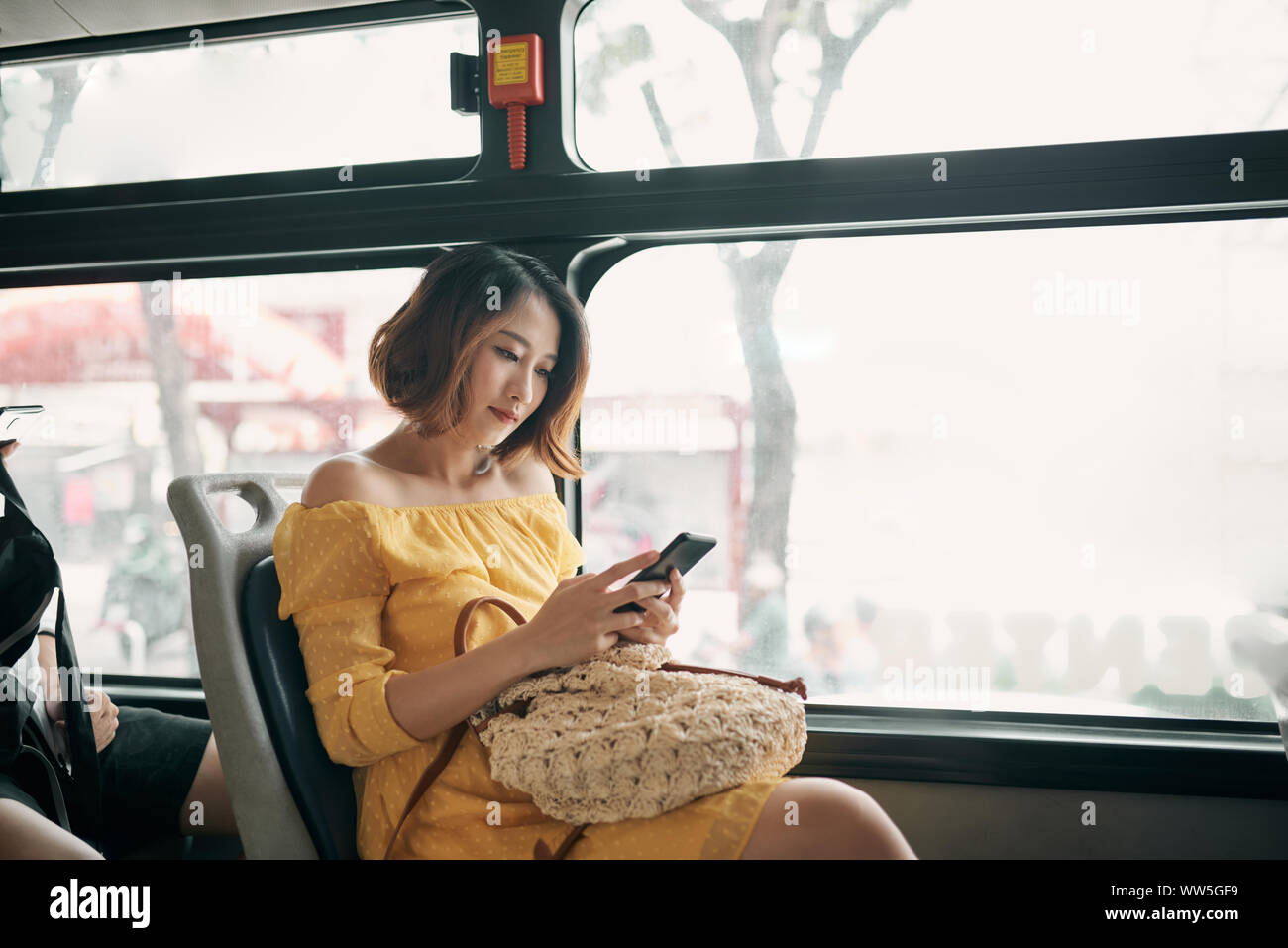 young beautiful asian woman browsing and typing messages in a public ...