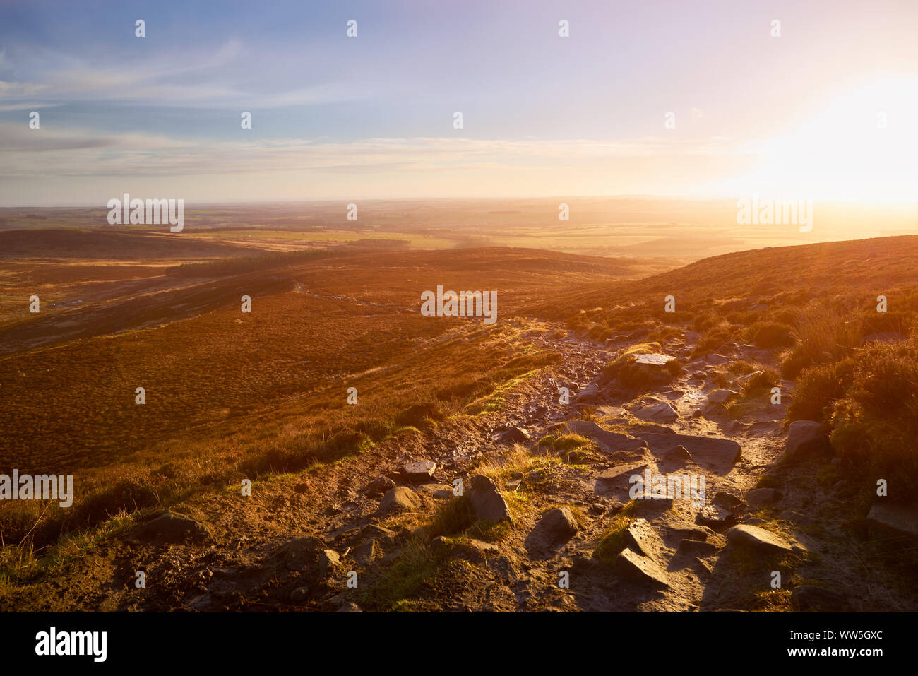 Red, Orange and yellow glow of a sunset over moors and hills in the ...