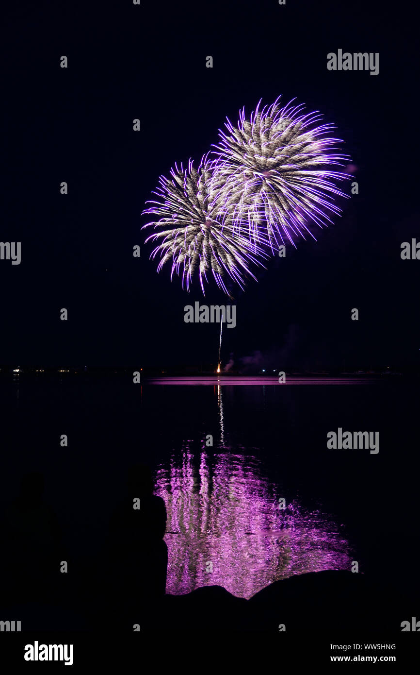 Purple fireworks reflected in the water Stock Photo - Alamy