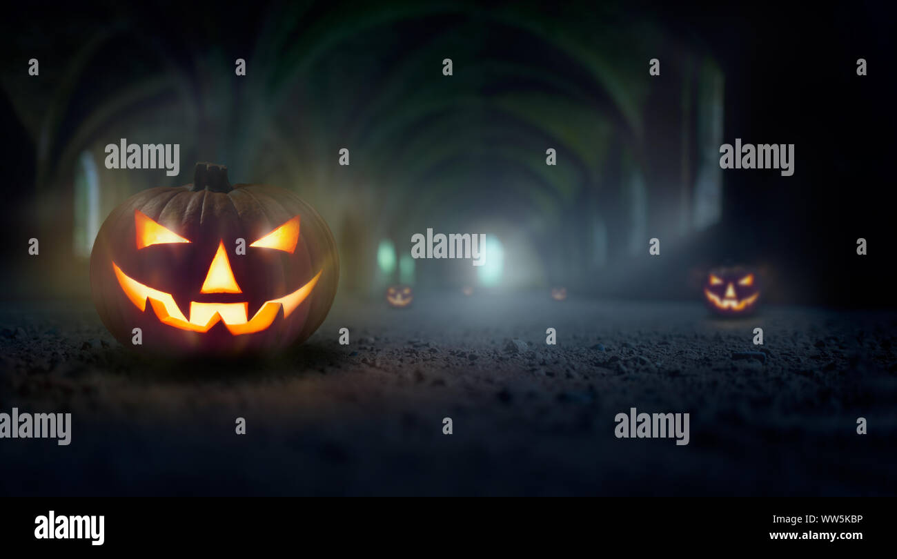 Jack O' Lanterns in a cold, misty and dark blue spooky ruins of an old ...