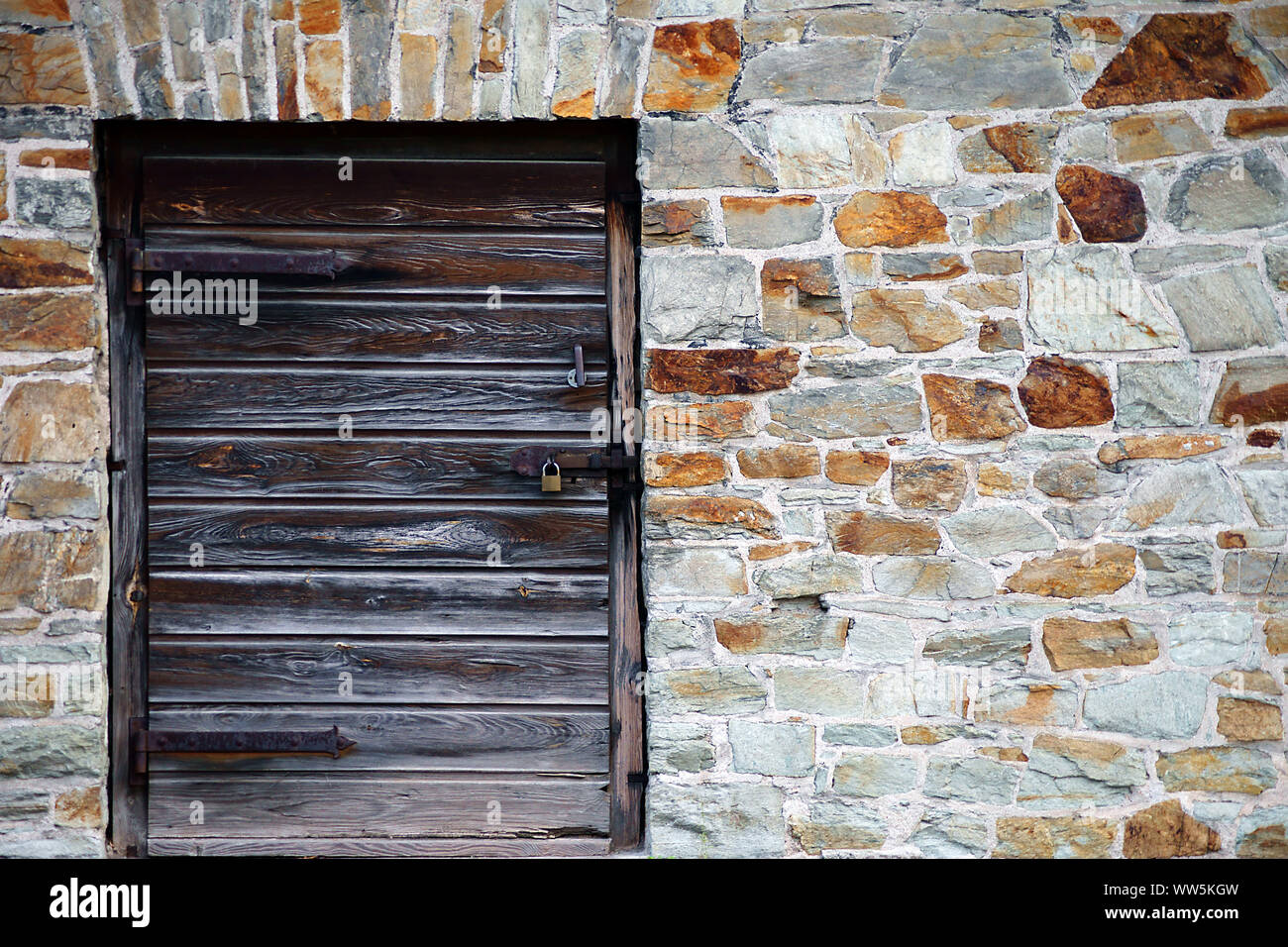 Photography of a hatch in a rock stone wall Stock Photo - Alamy