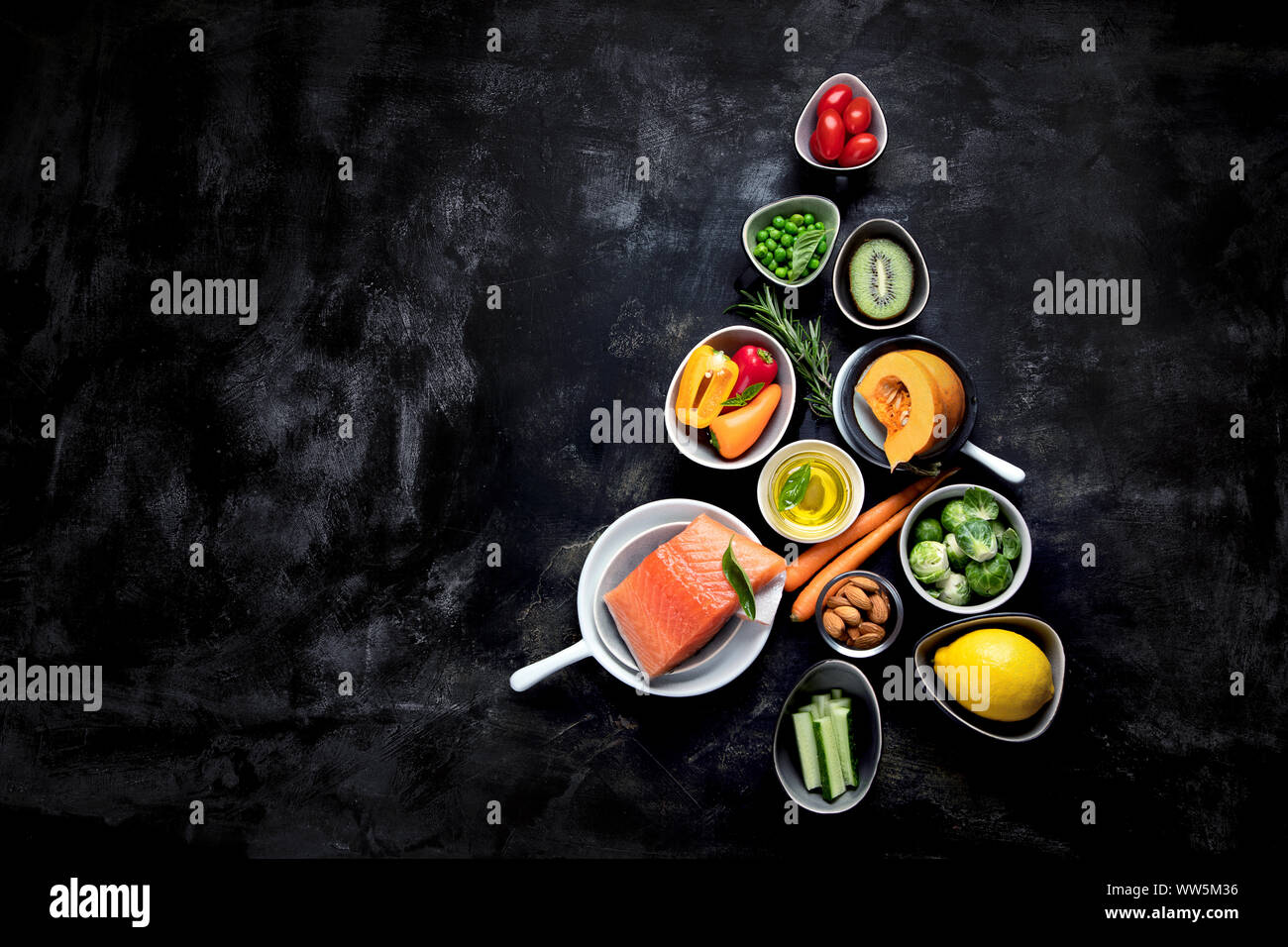 Christmas tree made of healthy food on black background. Top view with ...